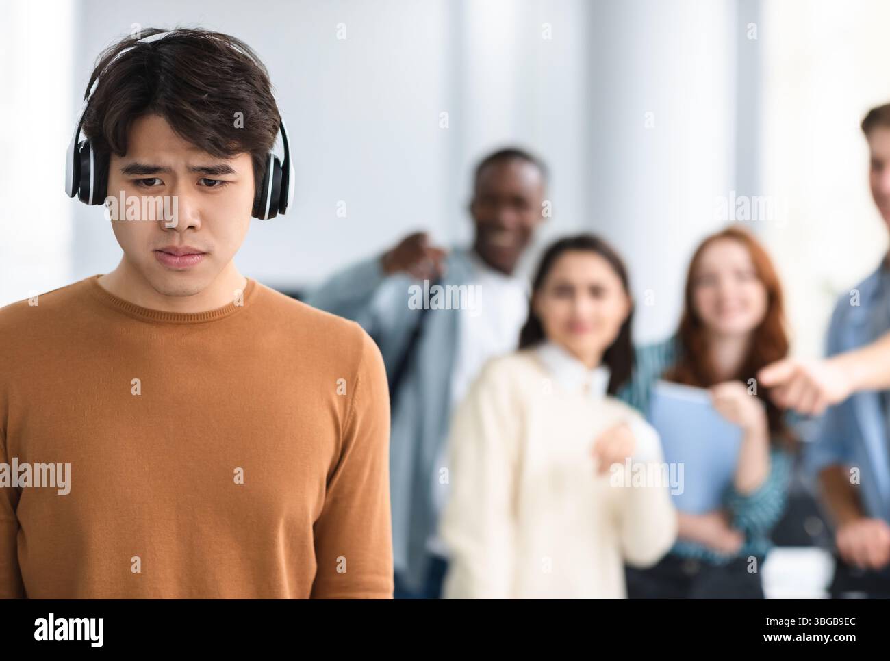 People mocking and making fun of sad asian man Stock Photo - Alamy