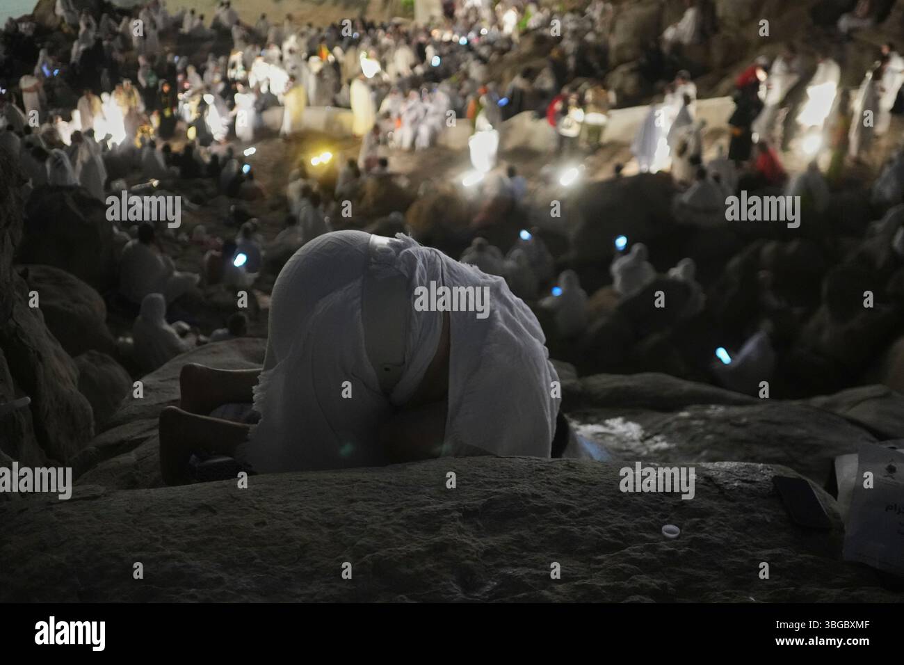 A Muslim pilgrim prays on the rocky hill known as the Mountain of Mercy ...