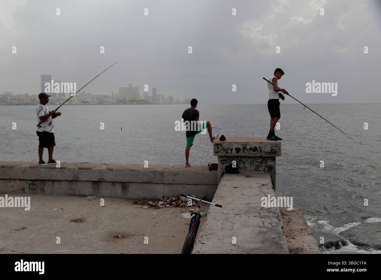 People fish from the boardwalk, as a cloud of dust from the Sahara ...