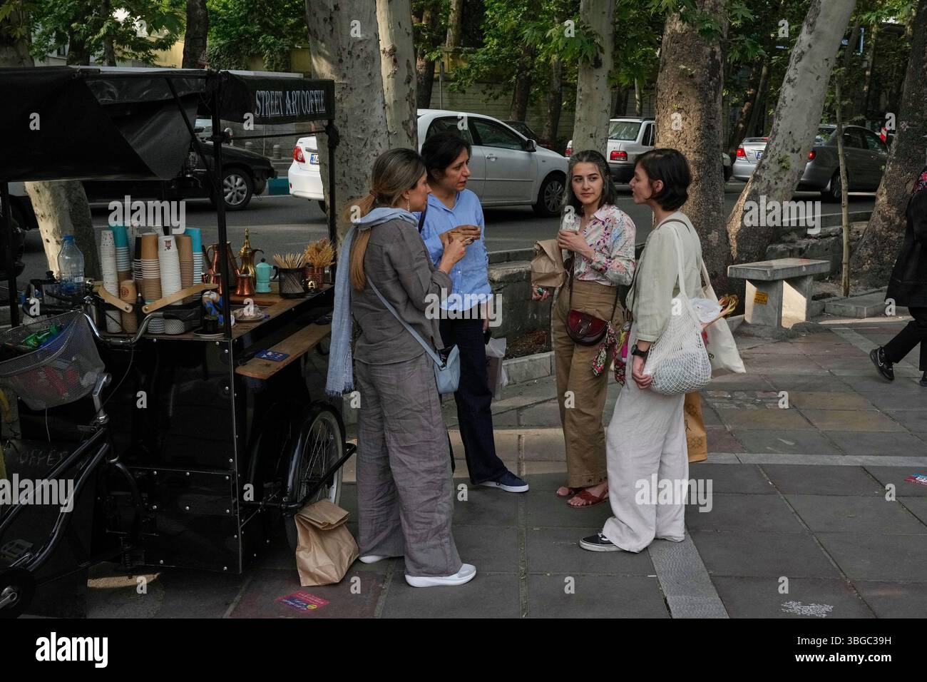 Iranian women drink coffee on the sidewalk in northern Tehran, Iran ...