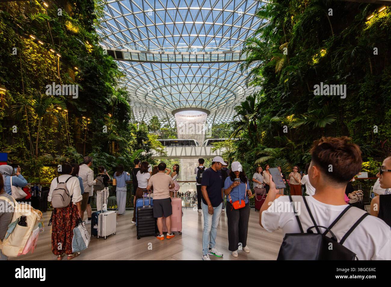 Rain Vortex, indoor cascading waterfall, passengers and tourists busy ...