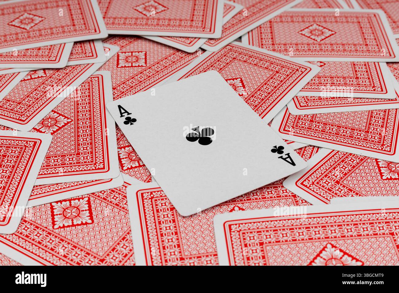 Ace of clubs revealed among red playing cards Stock Photo - Alamy