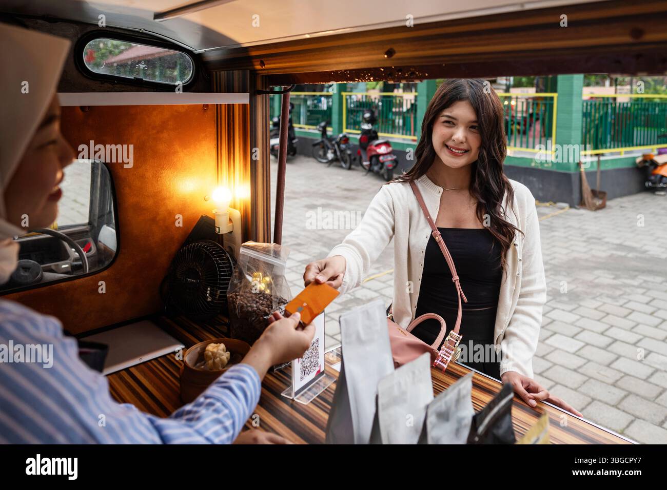 Indonesian southeast asian Chinese woman gives her debit card to a ...