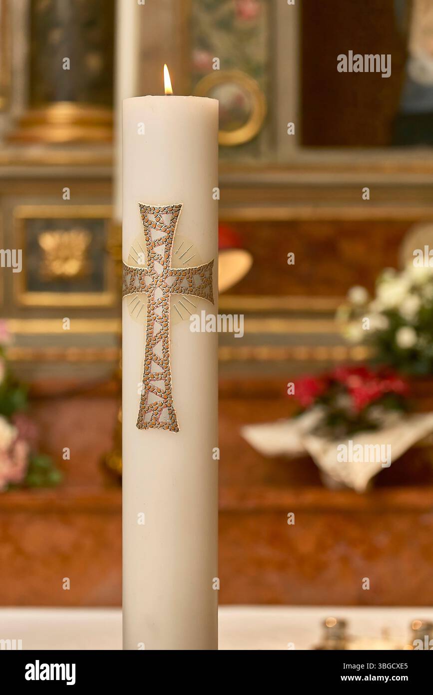 Lit paschal candle with decorative cross symbolizing jesus christ ...