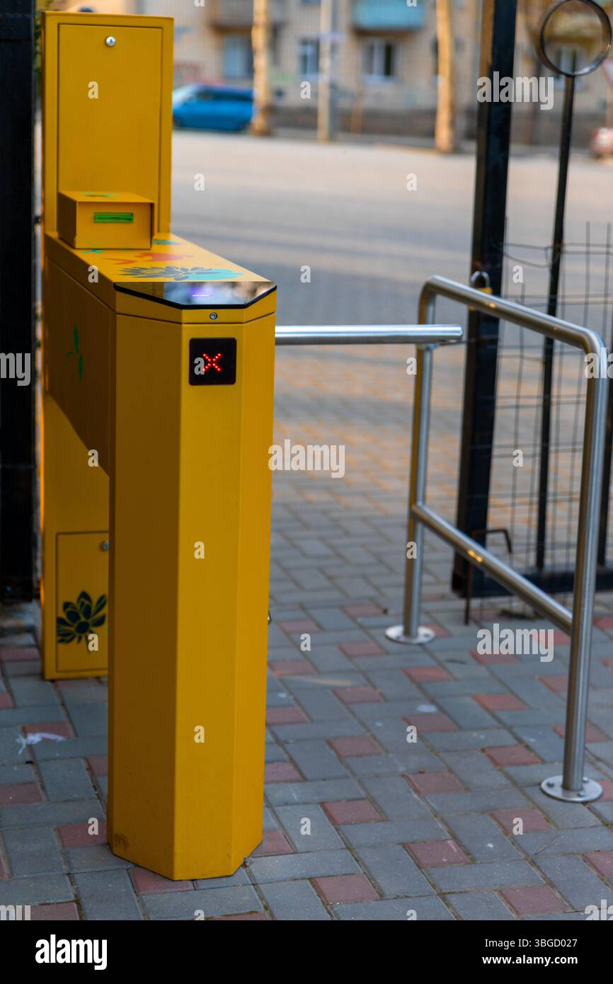 Bright yellow turnstile access gate with a red "X" indicator, situated ...