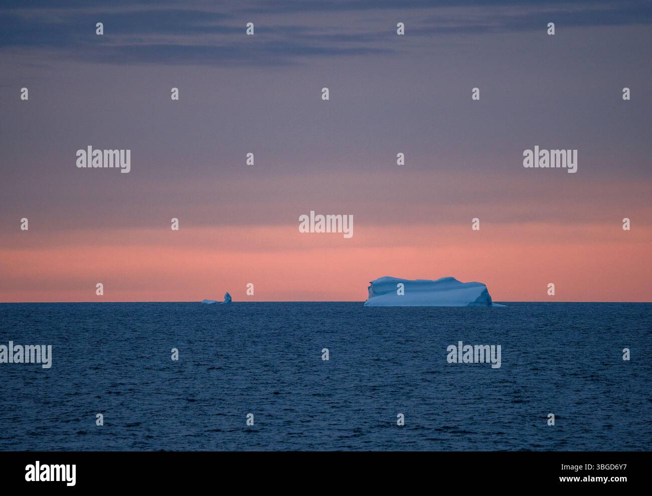 Distant icebergs drift in the Davis Strait, Greenland, beneath a soft ...