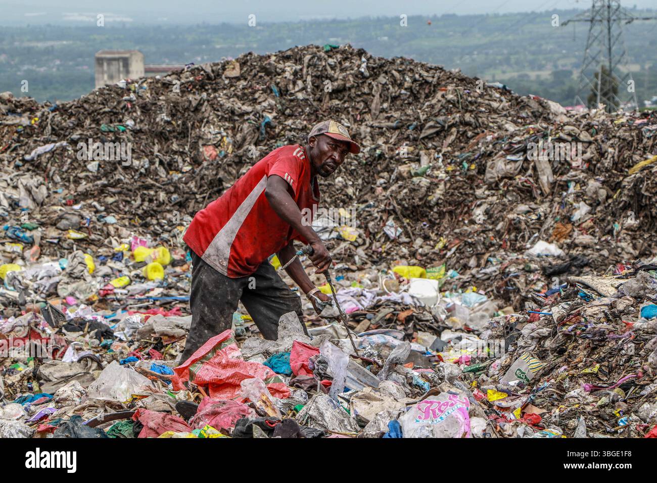 An informal waste worker collects materials to recycle at Gioto ...