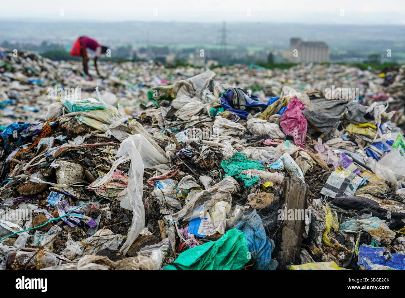 An informal waste worker collects materials to recycle at Gioto ...