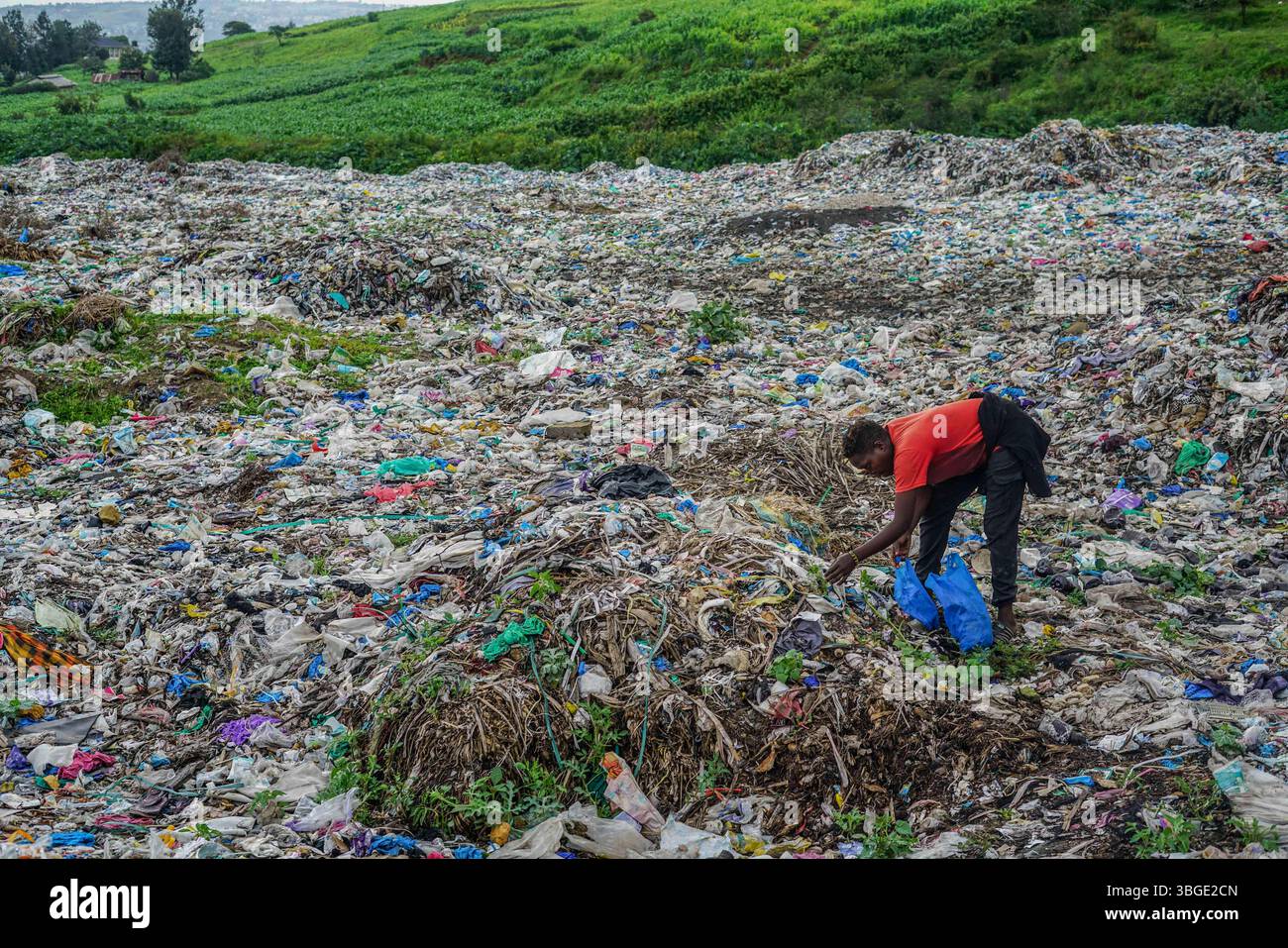 An informal waste worker collects materials to recycle at Gioto ...