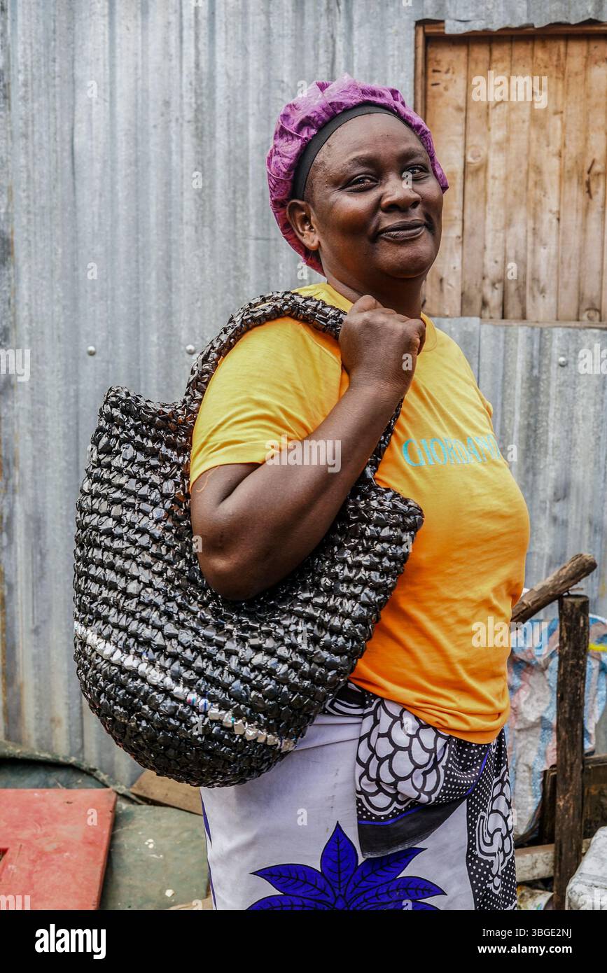 An informal waste worker displays a basket made from plastic waste at ...