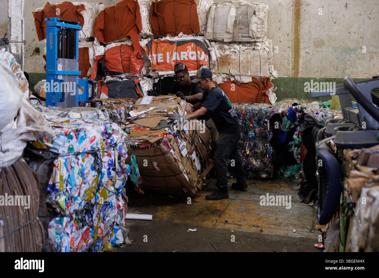 Rio De Janeiro, Brazil. 4th June, 2025. Workers move a bale of ...