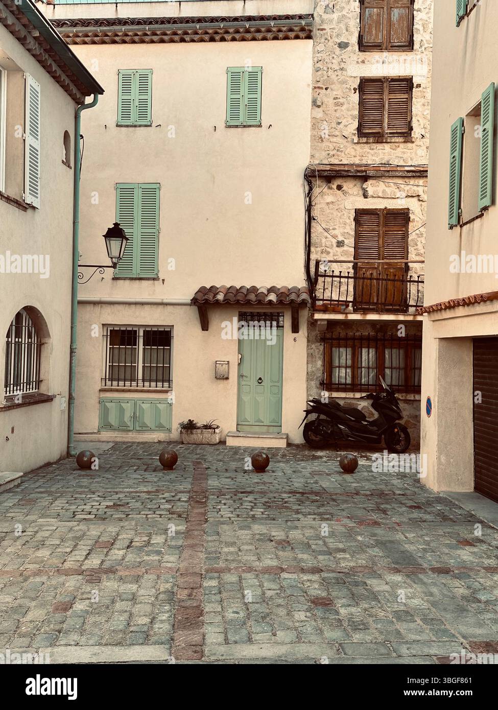 Charming European courtyard with cobblestone ground and pastel building ...