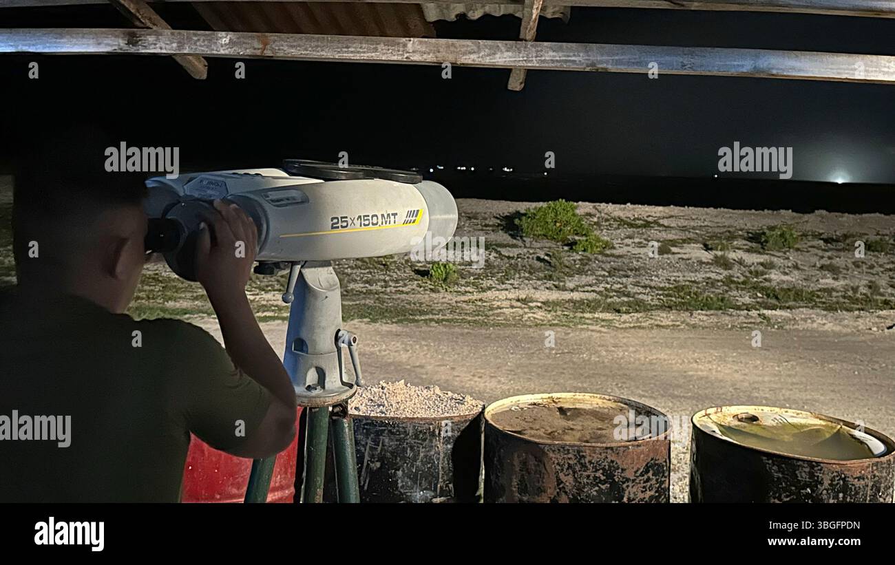 Philippine soldier views Subi Reef using binoculars from Philippine ...