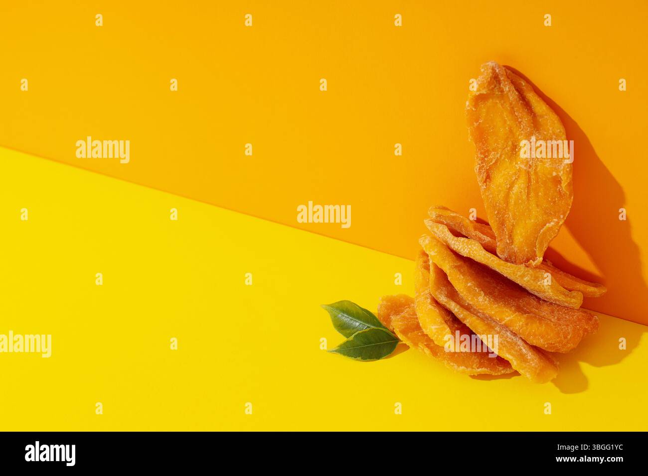 Dried mango chips on a yellow background Stock Photo - Alamy