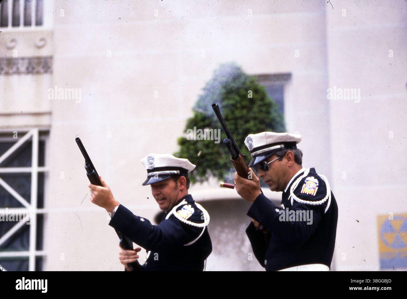 In June 1984, two officers present arms and fire a gun salute in front ...