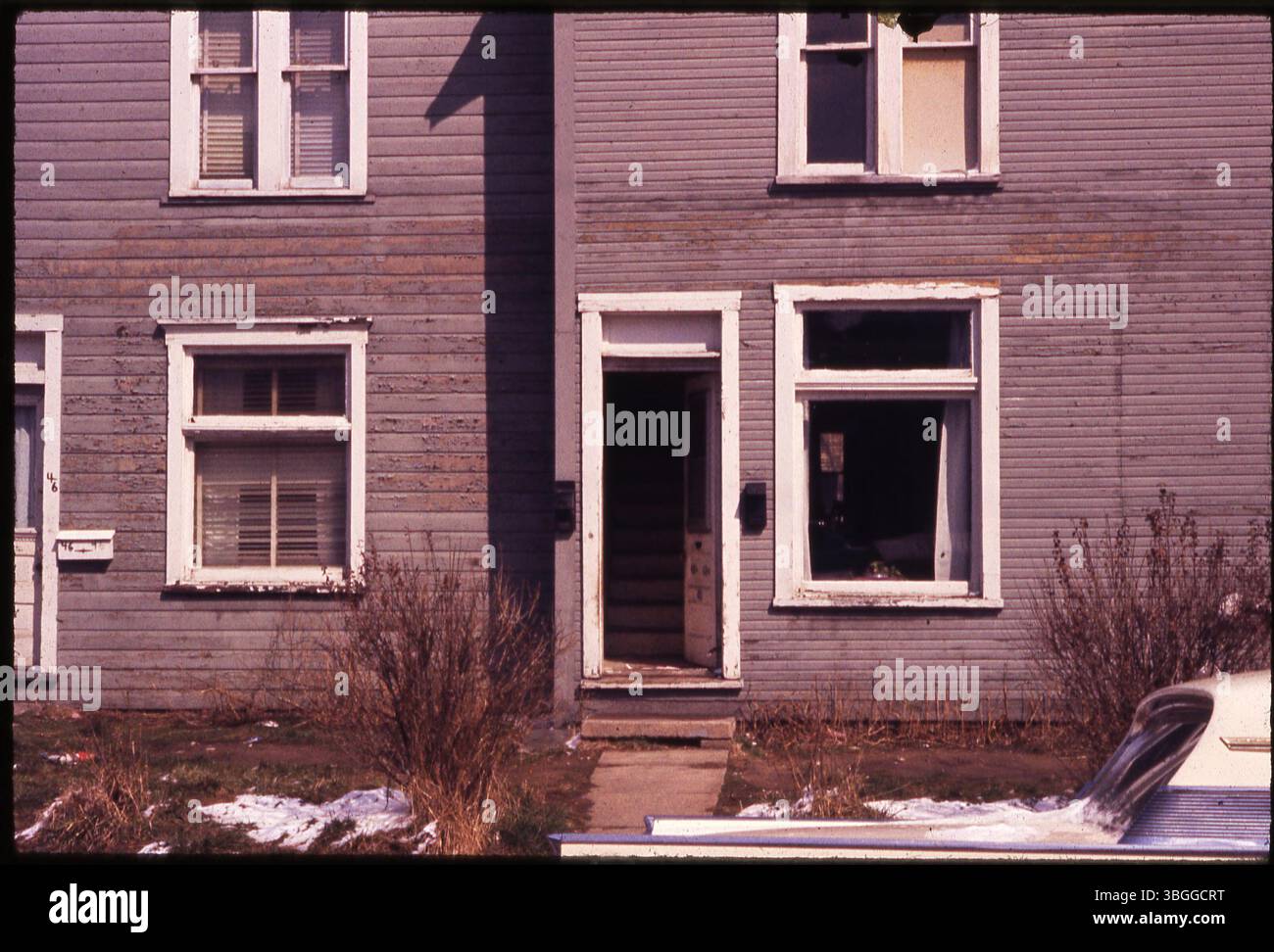 An unidentified, vacant wood-framed multiple family dwelling in poor condition with doors and ...
