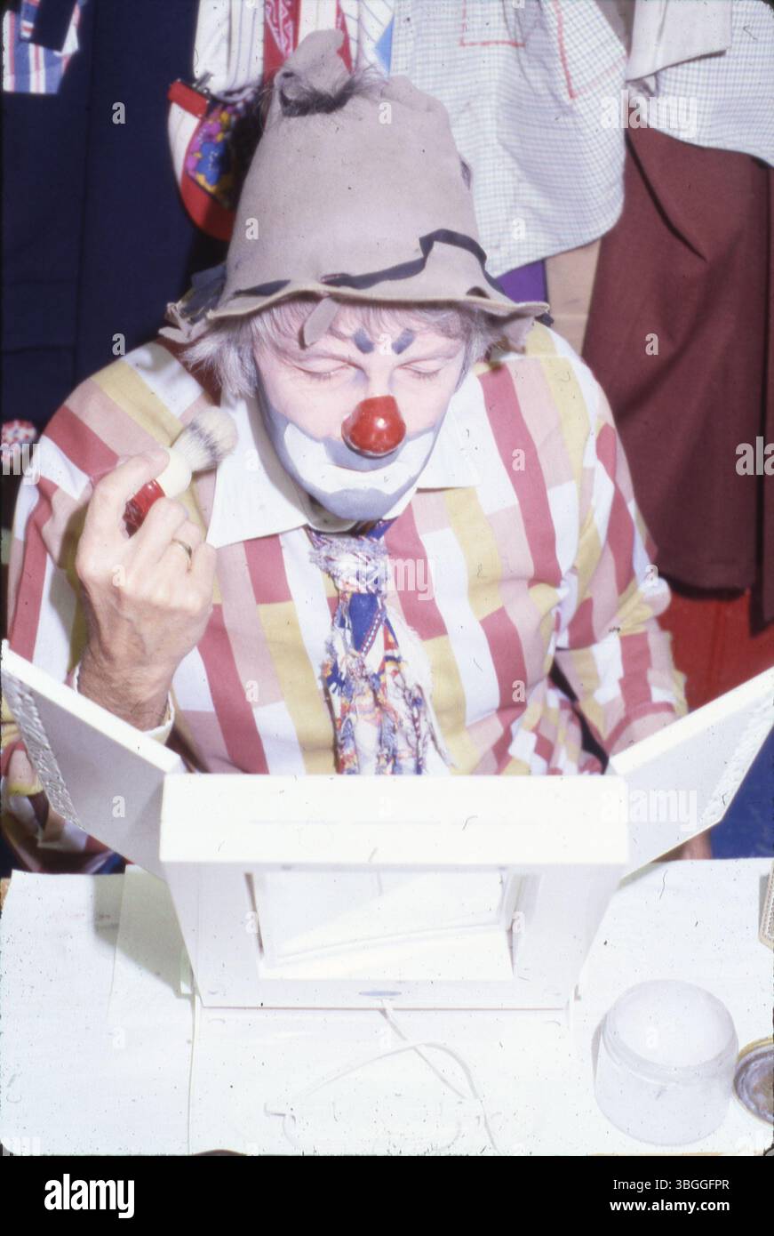 This photograph features a clown preparing his costume before ...