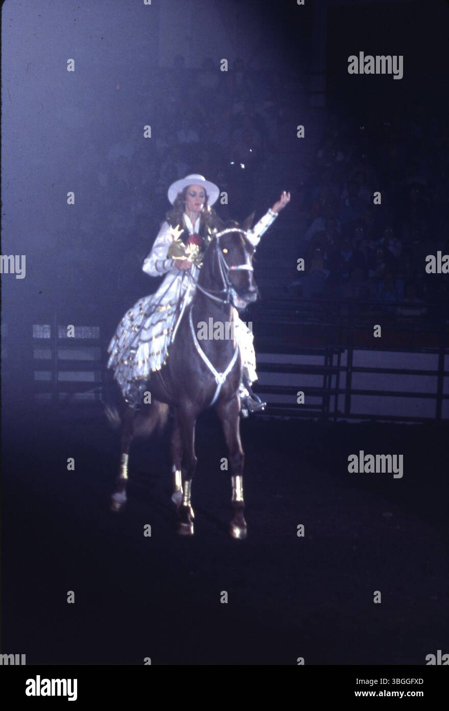 A woman in a white hat and dress rides a horse during the All American ...