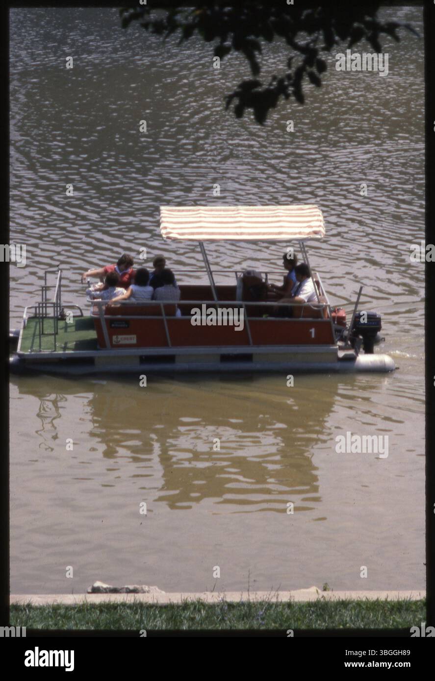 A pontoon boat with a canopy top motors along the Scioto River in ...