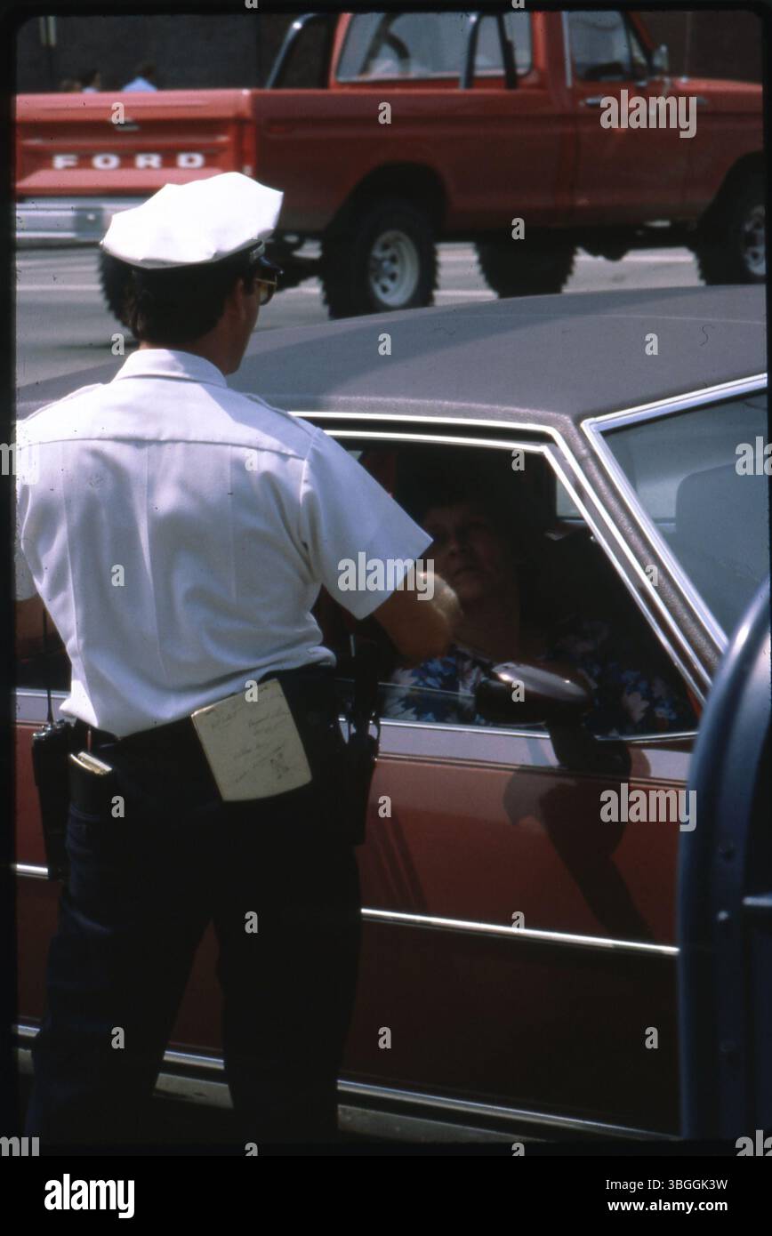 A Columbus Police officer stands speaking through an open car window to ...
