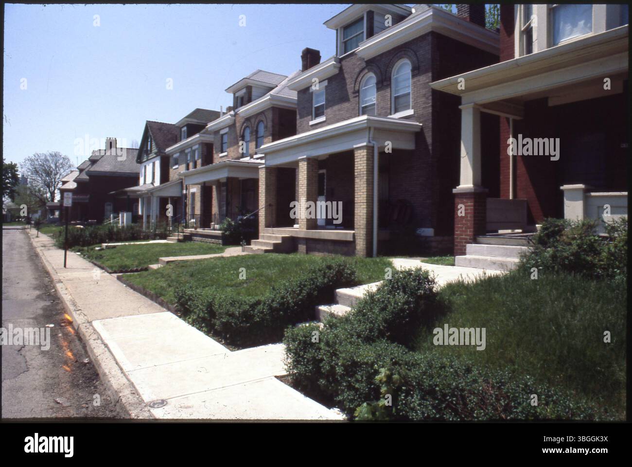 A street scene from 1978 featuring multi-story brick homes. Two homes ...