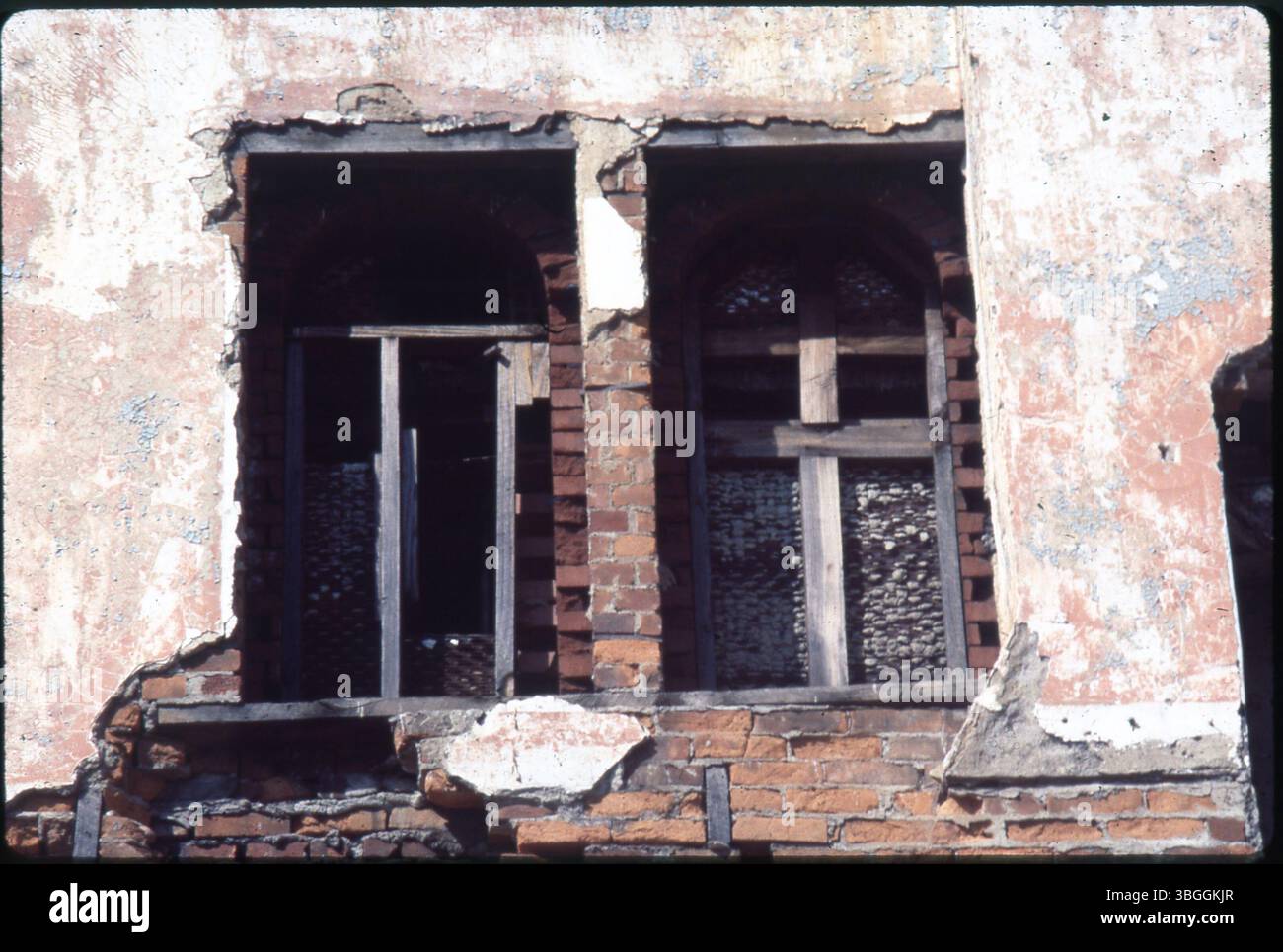 A view showing two arched brick windows uncovered behind rectangular ...