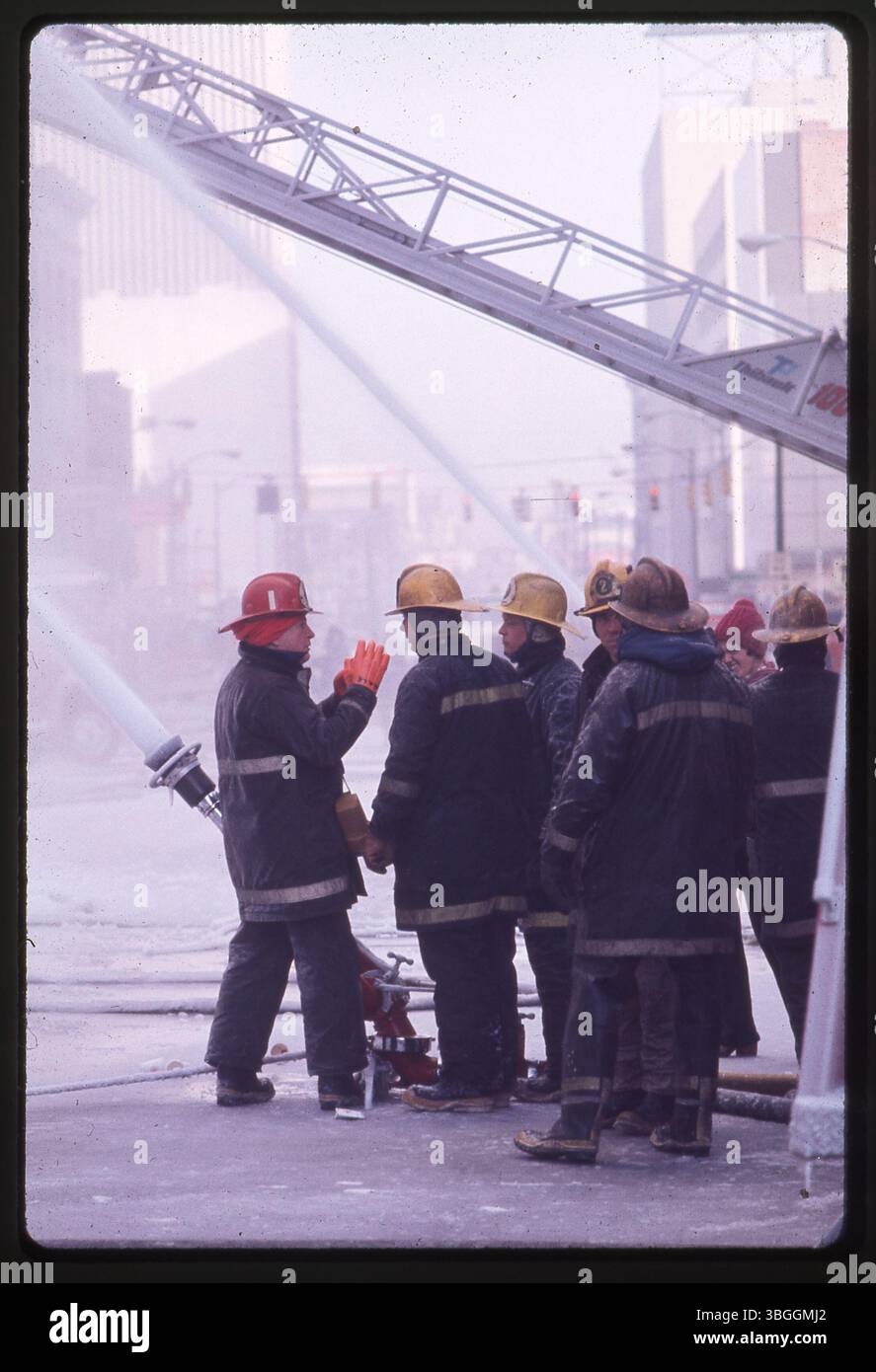 This circa 1977 image shows a group of firefighters in yellow helmets ...