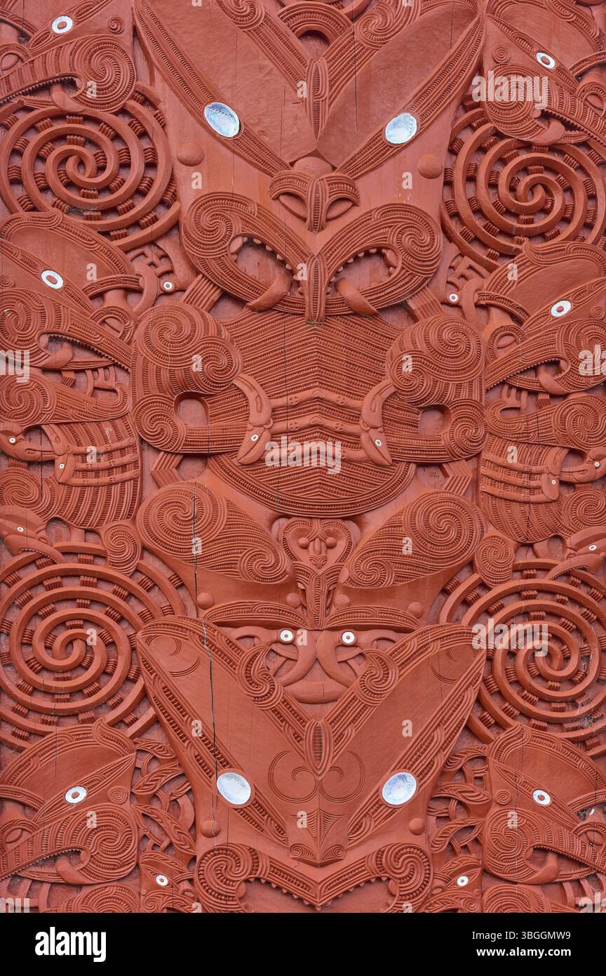 Close-up of a symmetrical MAori wood carving with red decorations, New ...