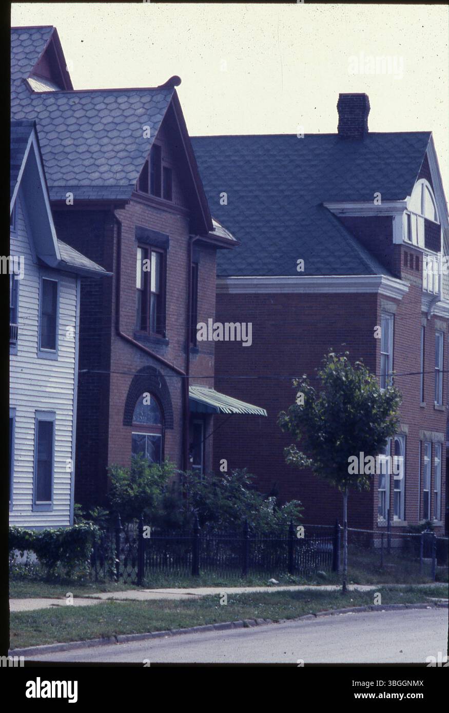 This street scene includes three buildings: a two-story wood frame ...