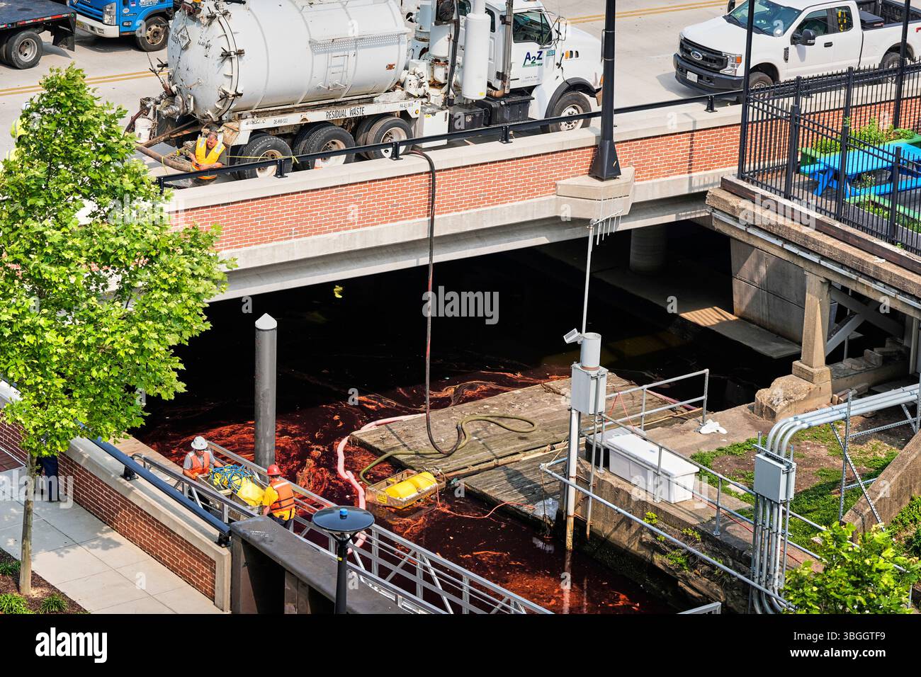 Crew members work to clean up and contain a 2,000-gallon diesel fuel ...