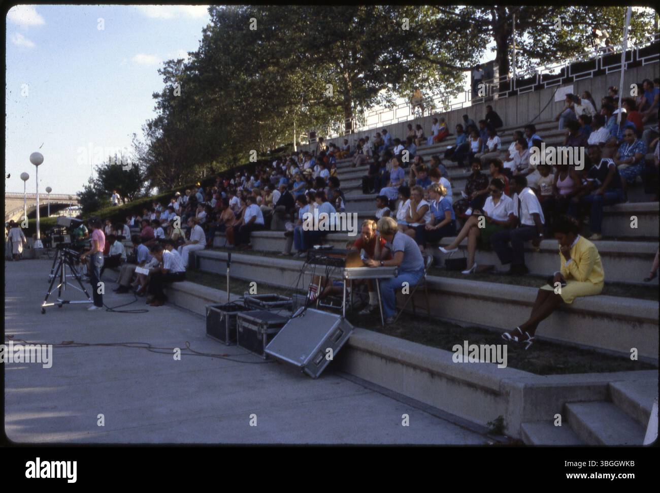 Audience seated on grassy steps of the Riverfront Amphitheater in 1983 ...