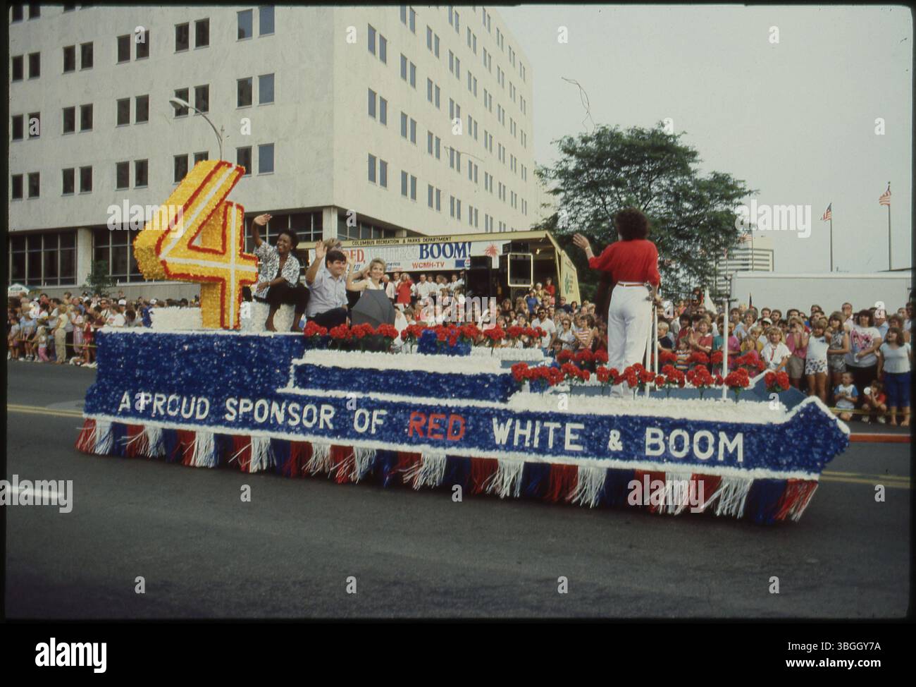 In this image, a float featuring two men and two women waves to the ...