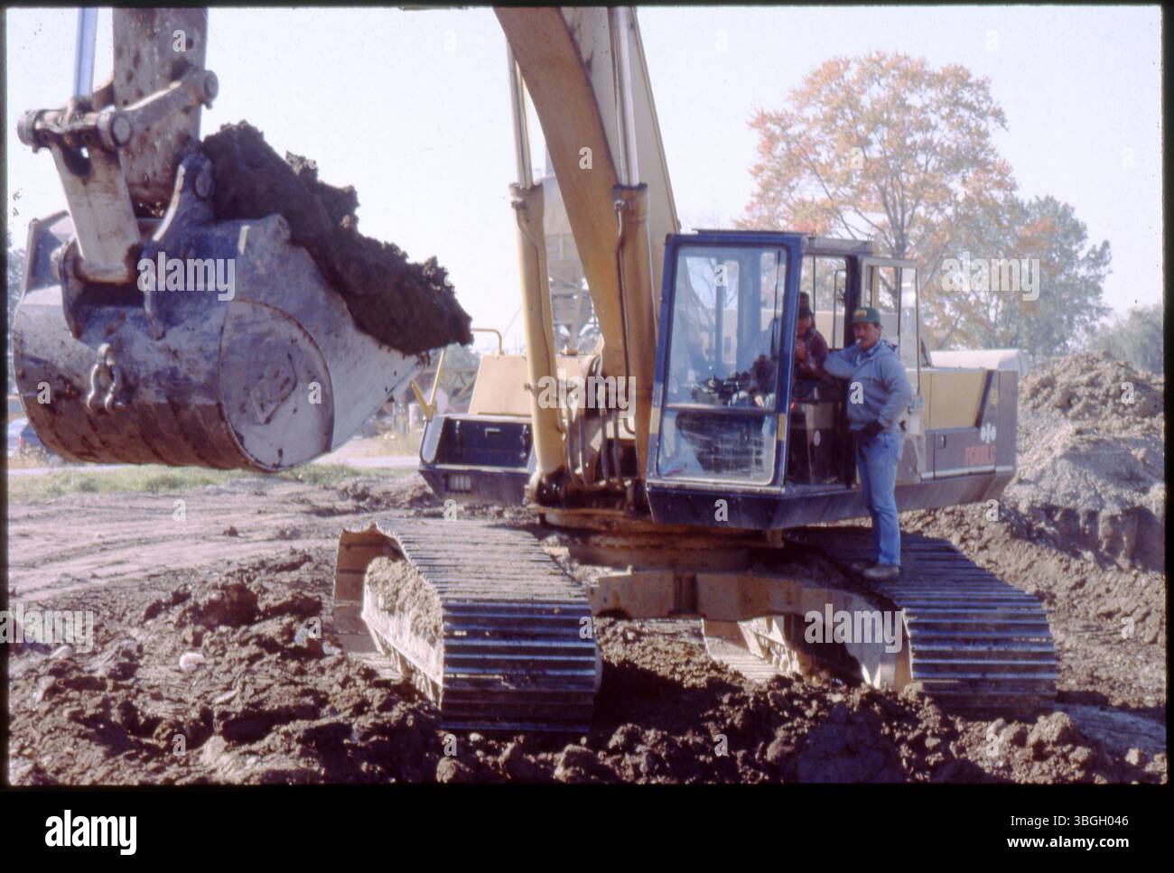 In the 1980s, one construction worker operates an excavator to move ...