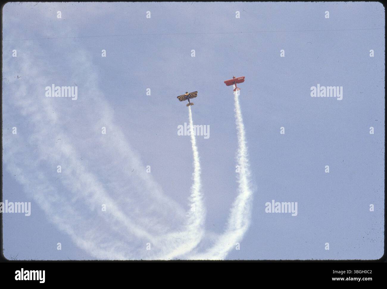 Two biplanes perform side-by-side loops during an air show in 1990. One ...