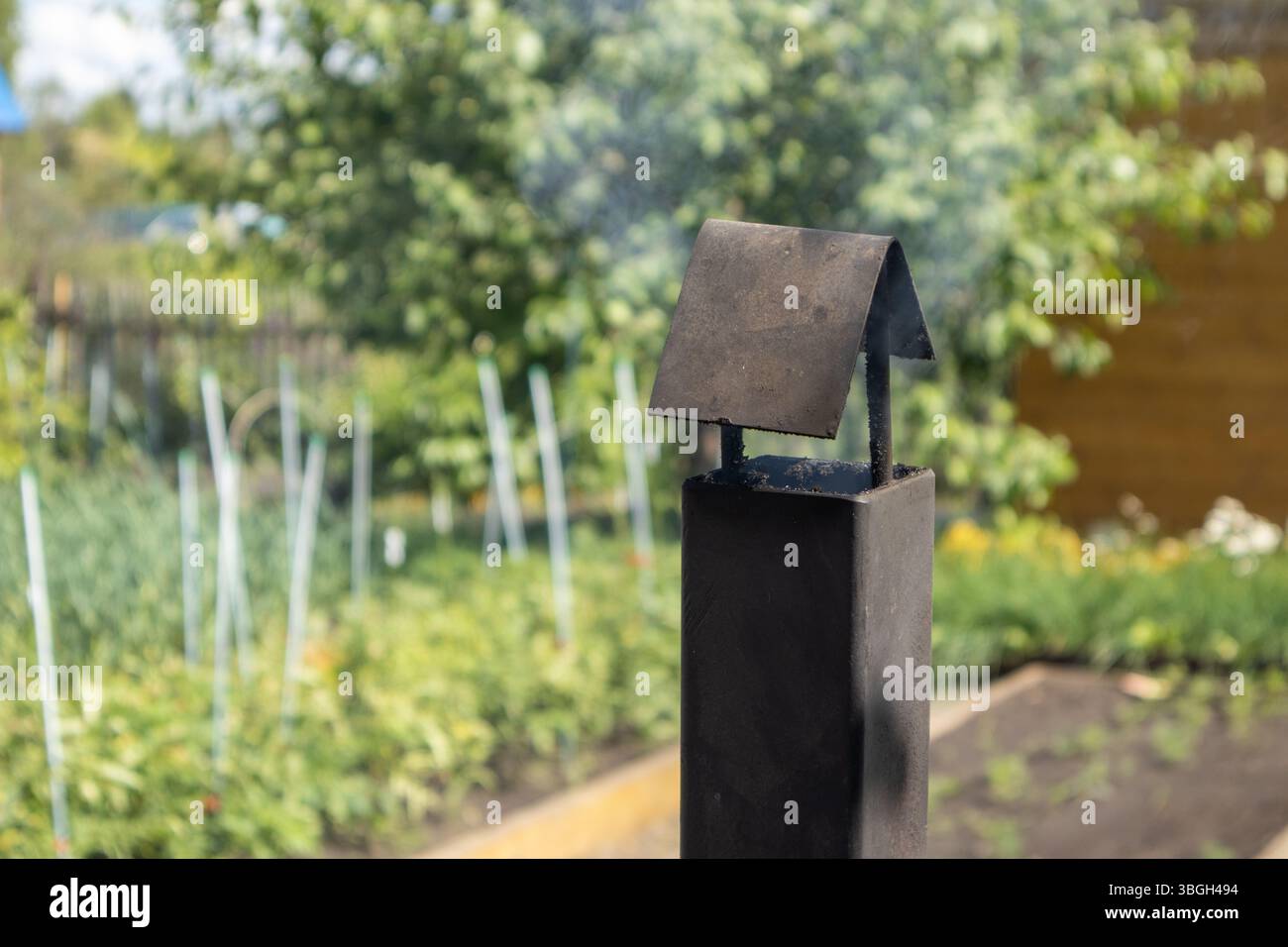Vintage iron pipe chimney with corner umbrella. Close-up of a pipe from ...