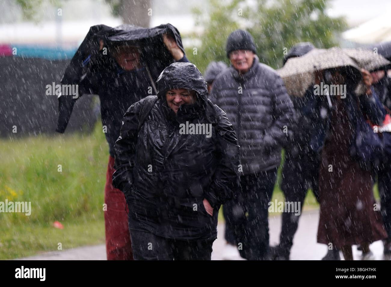 Spectators during a heavy rain shower on day four of the Lexus ...