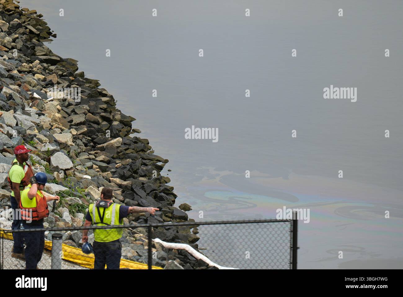 A crew member works to clean up and contain a 2,000-gallon diesel fuel ...