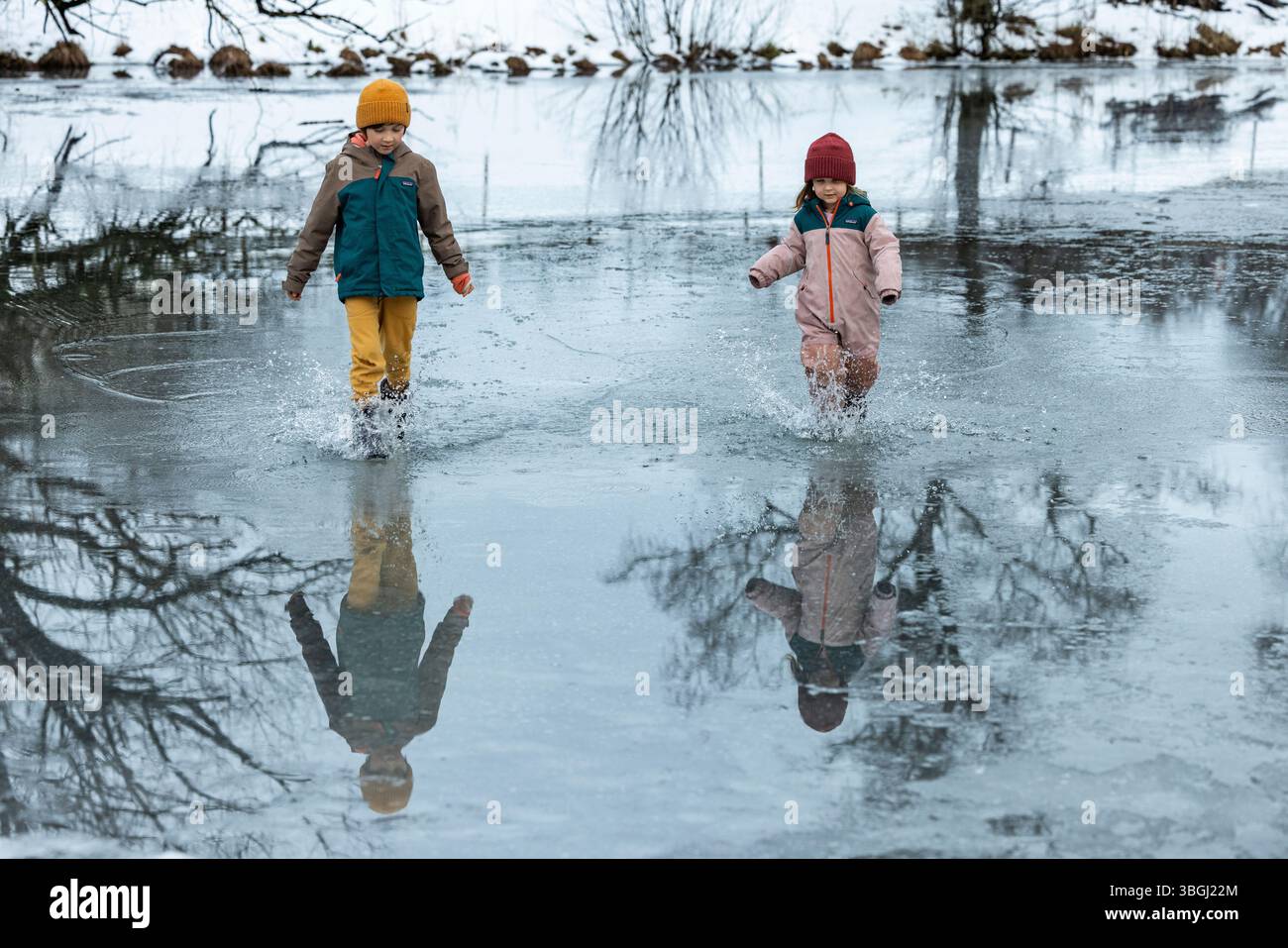 Children running through a large puddle in winter Stock Photo - Alamy