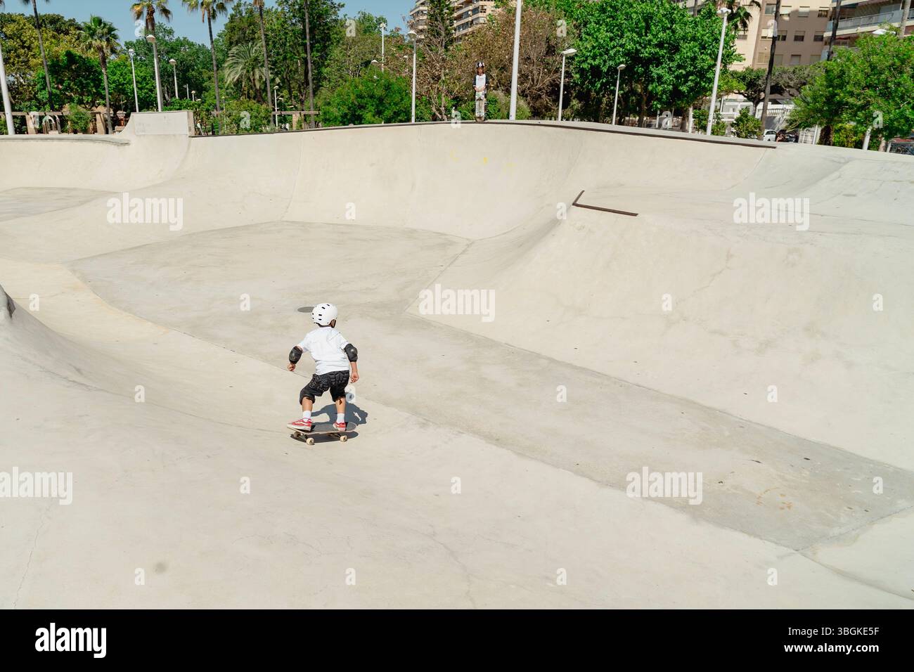 Child skateboarding in a skatepark, demonstrating safety and skill ...