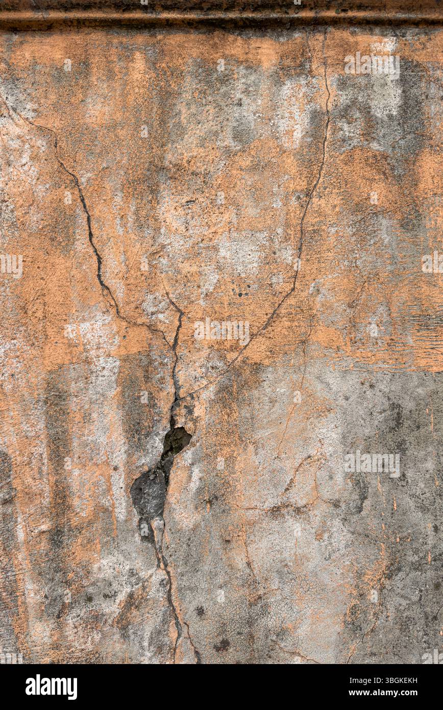 Cracked old plaster wall with deep fractures, peeling paint, and ...