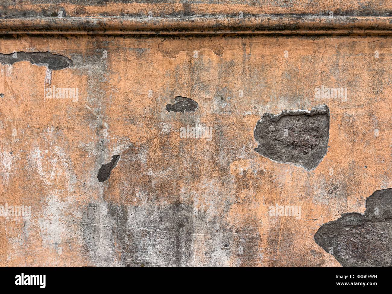 Damaged plaster wall with peeling paint, exposed concrete patches and ...