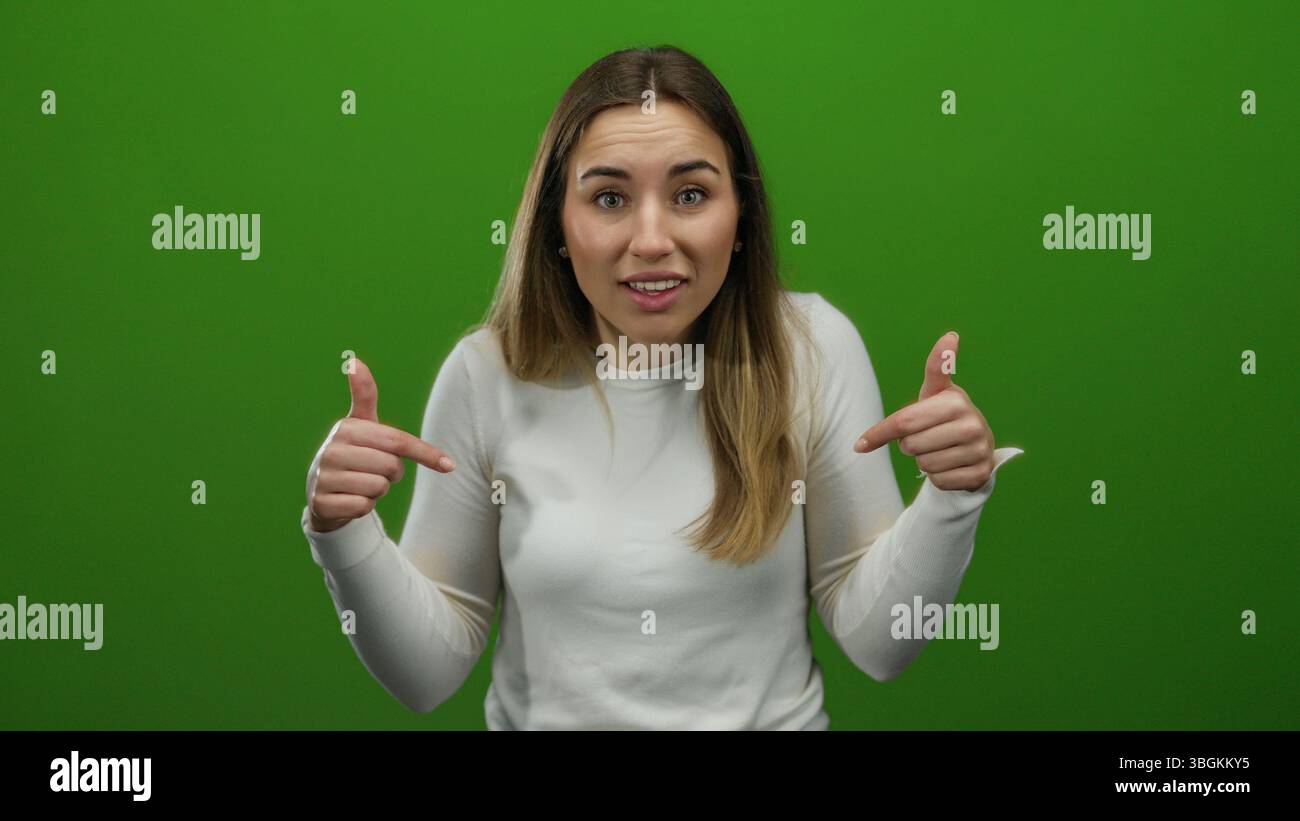 Woman expressing confusion with hand gestures over an isolated green ...