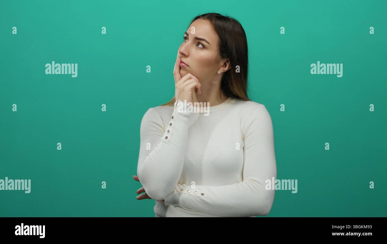 Woman thinking deeply, appears pensive and contemplative, wearing white ...