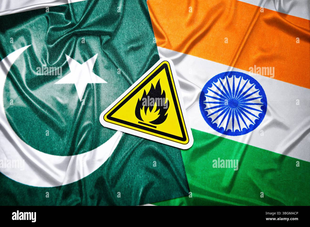 Danger sign with fire symbol on the flags of Pakistan and India ...