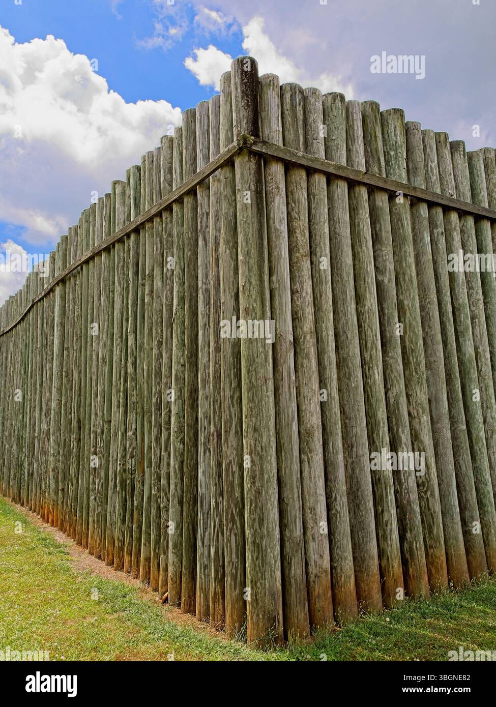 Corner of reconstructed wooden log stockade wall under cumulus clouds at Andersonville National ...