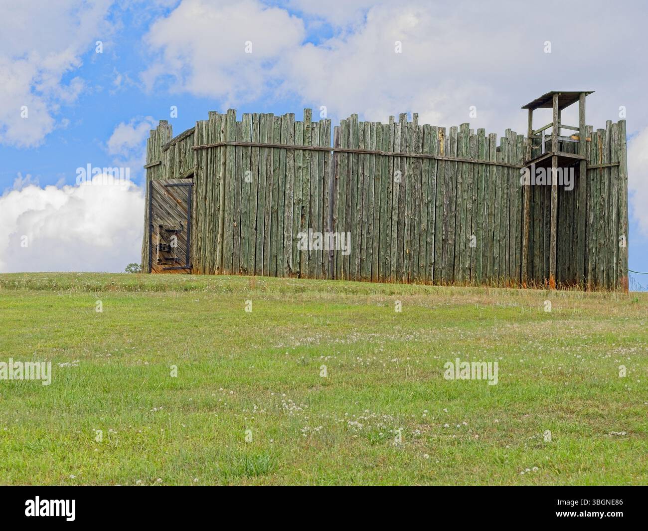 Wooden log stockade on knoll with pigeon roost watchtower under cumulus ...