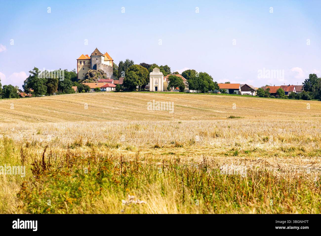 Kamen Castle in front of a harvested grain field in the Bohemian ...