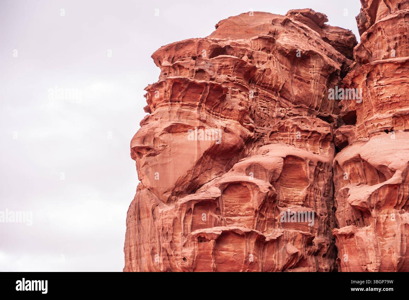 A large rock formation with a face carved into it. The face is carved ...