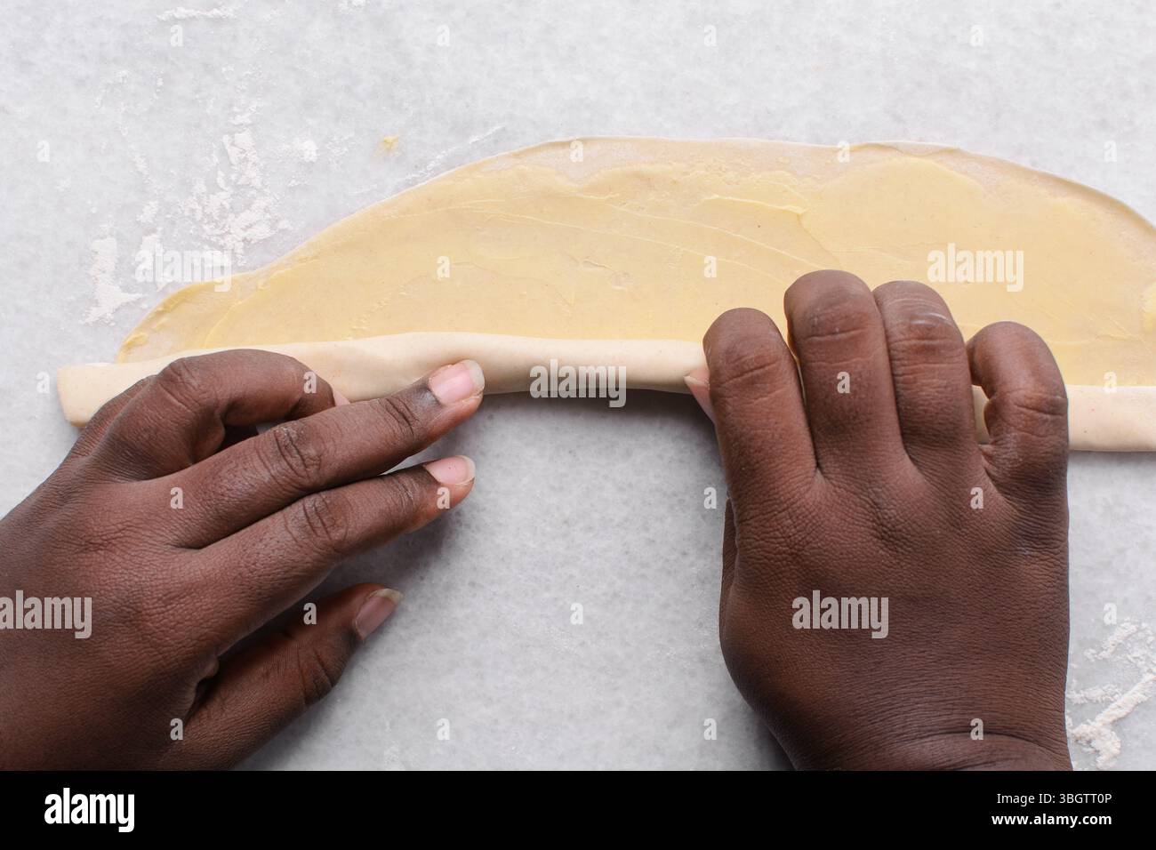 Overhead view of rolled paratha dough on a marble countertop, top view ...