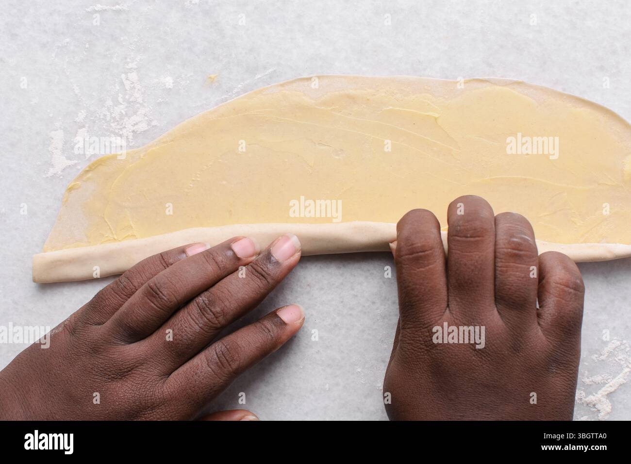 Overhead view of rolled paratha dough on a marble countertop, top view ...